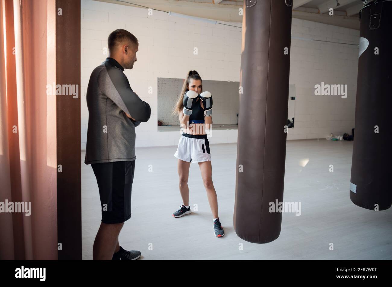 Woman training boxing with personal trainer. Instructor teaching female ...