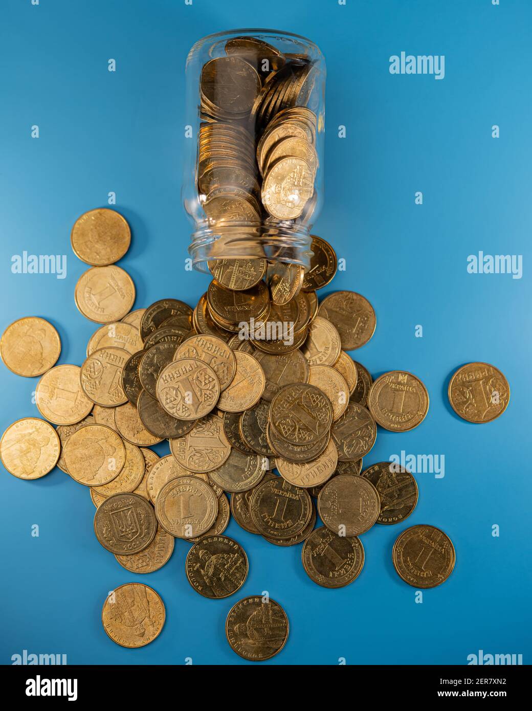 inverted glass jar with coins and coins lying around. Business concept ...