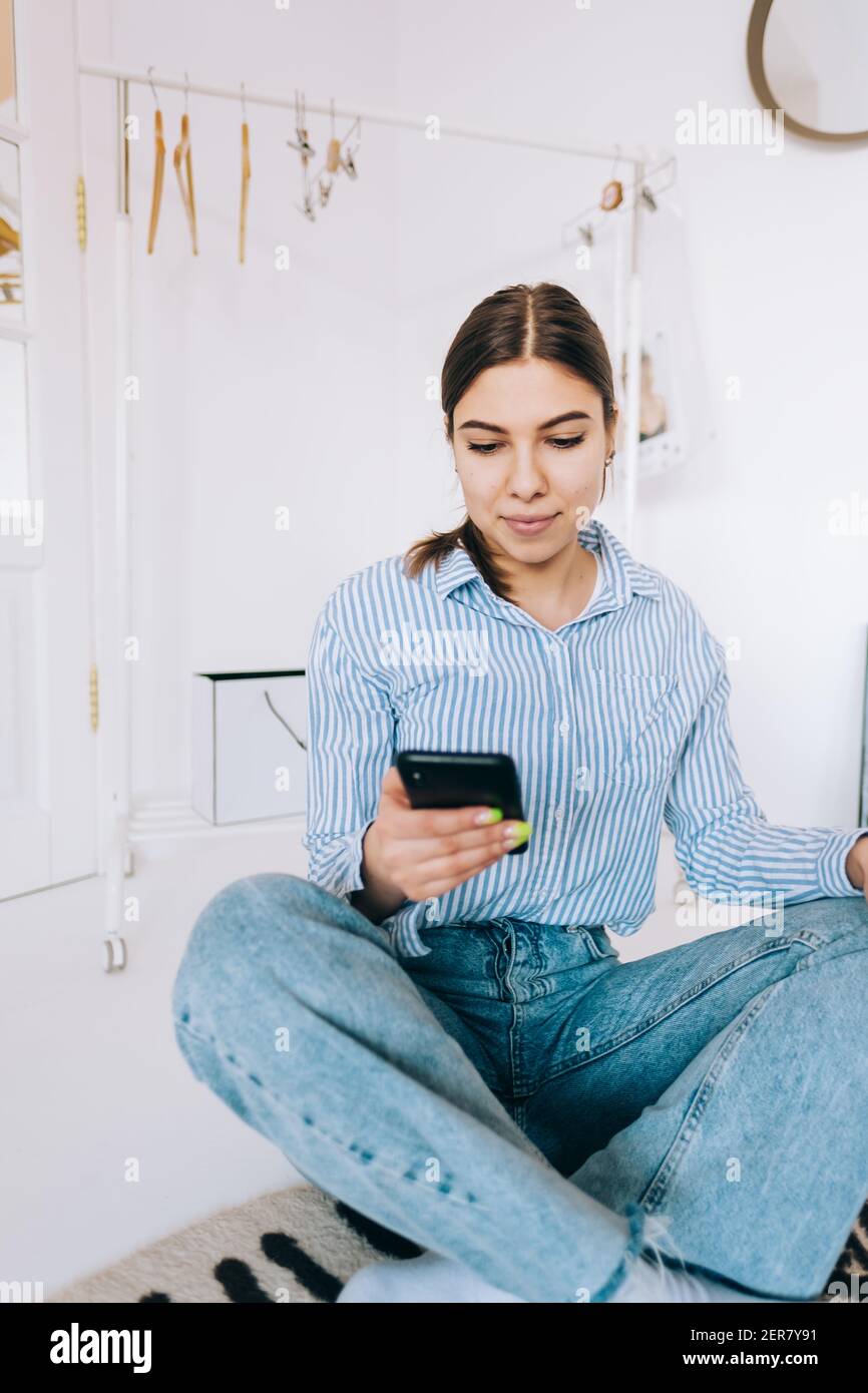 Woman sitting on floor looking at wardrobe and clothes hi-res stock ...