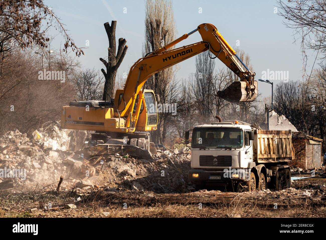 Building demolition Hyundai digger loading a truck while clearing a ...