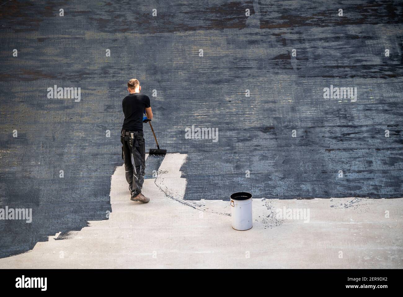 Construction site, application of a bituminous coating on a concrete ...