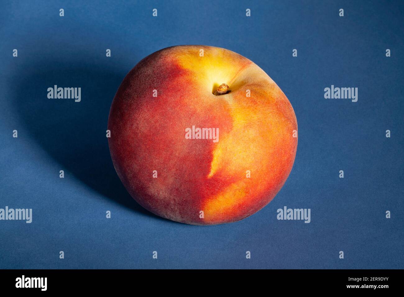 one peach on blue background Stock Photo - Alamy