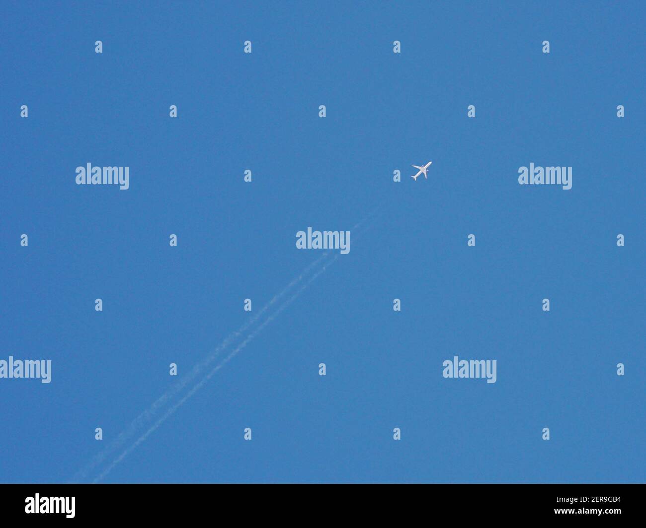 Airliner flying at altitude with vapor trails Stock Photo - Alamy