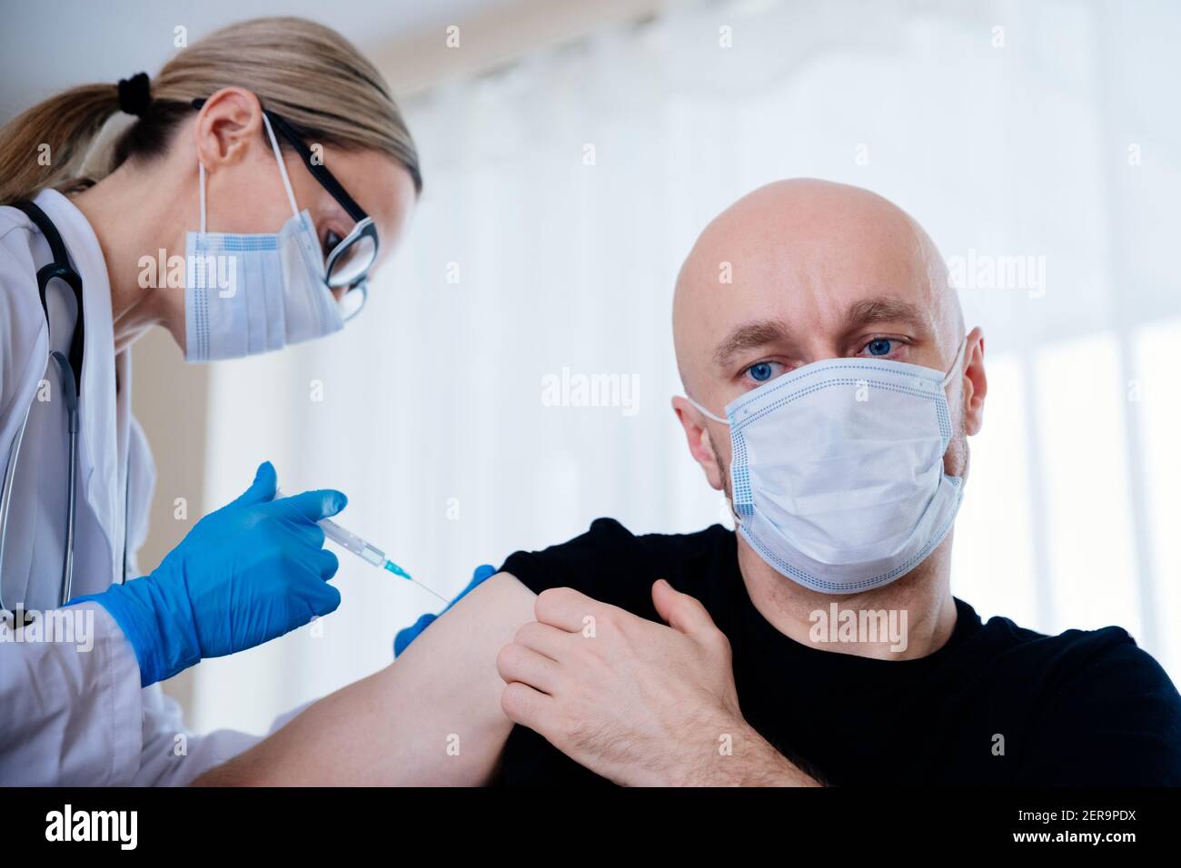Young female doctor giving injection to patient Stock Photo - Alamy