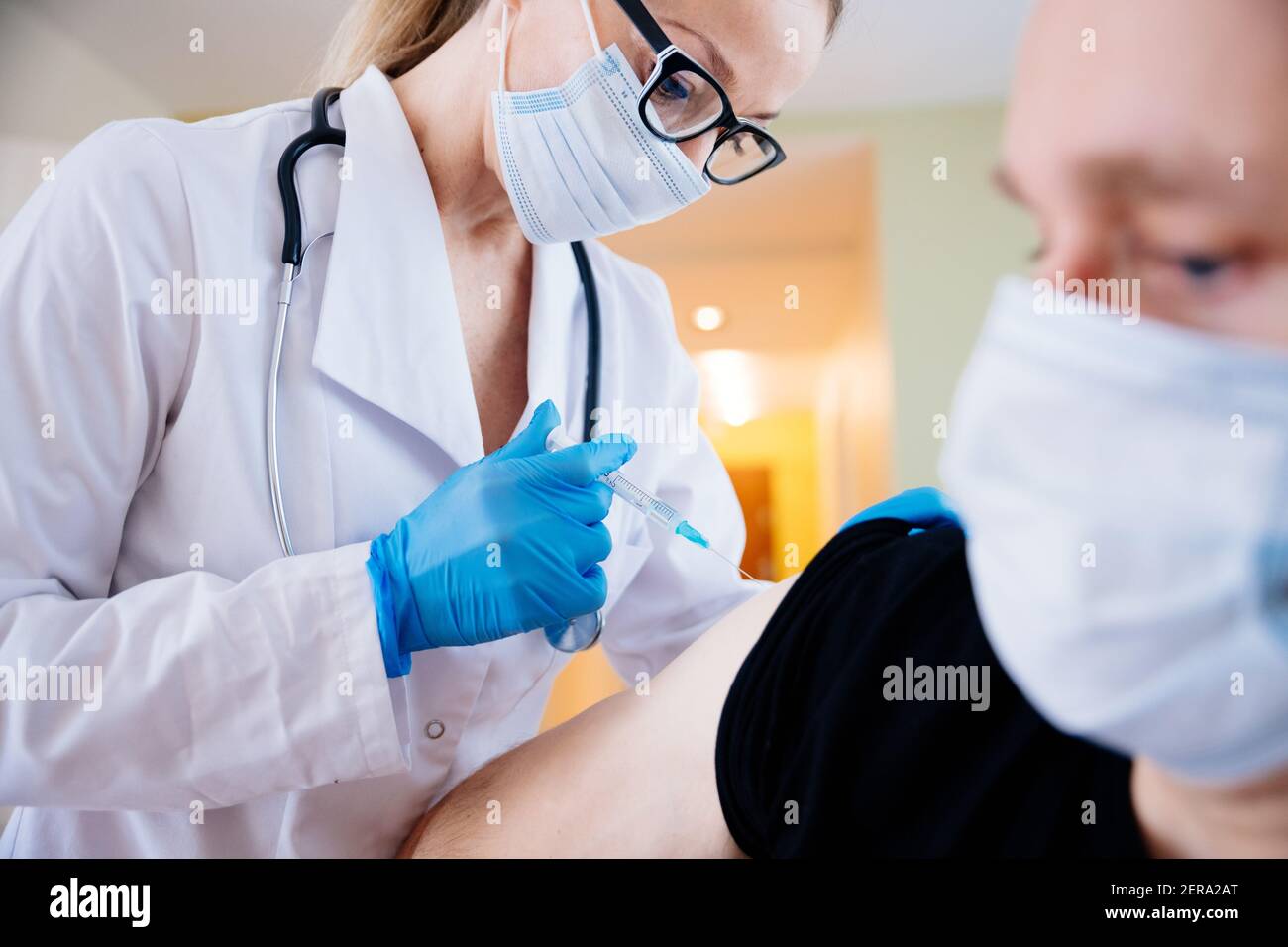 Doctor giving injection to young man at hospital Stock Photo - Alamy