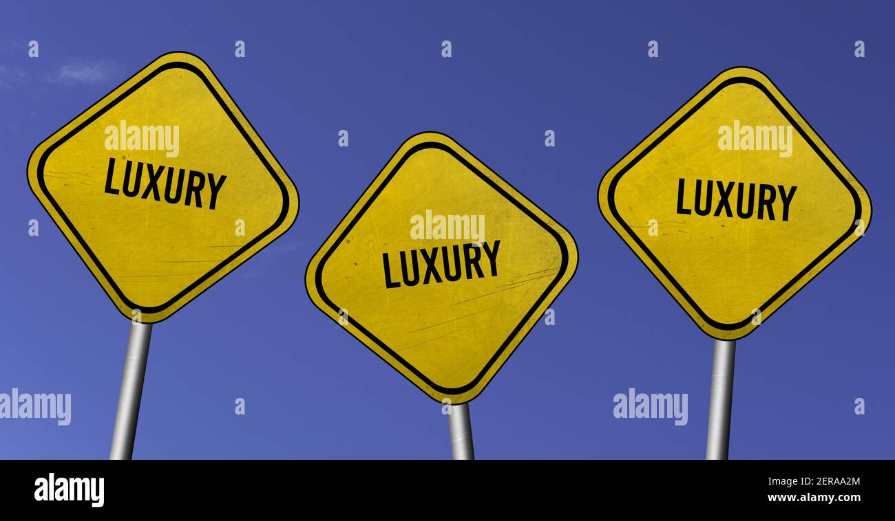 luxury - three yellow signs with blue sky background Stock Photo - Alamy