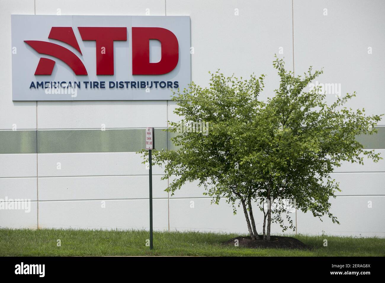A logo sign outside of a facility occupied by American Tire ...