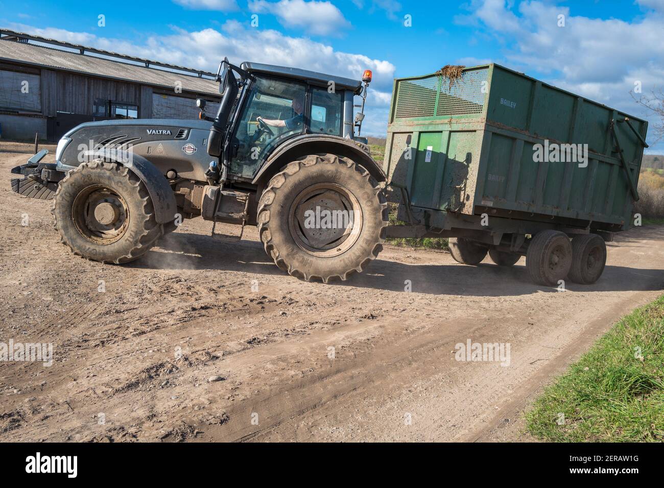 Valtra T173 tractor pulling a large trailer along a dusty lane Stock ...