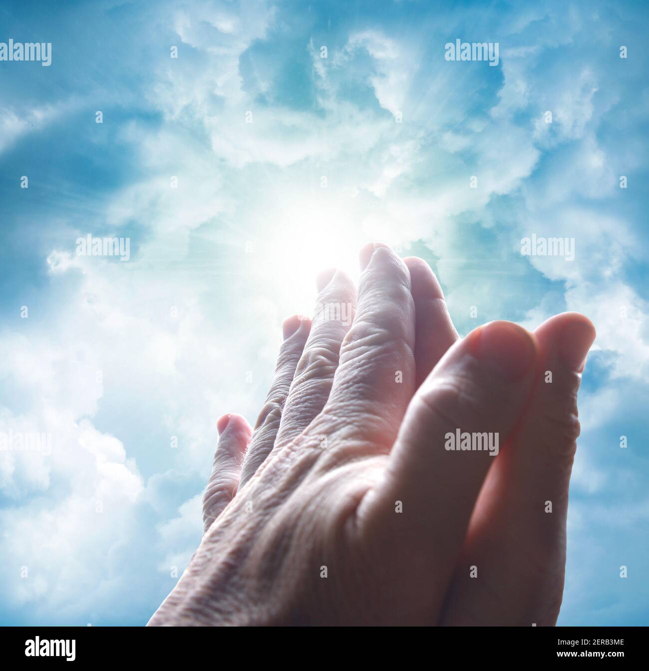 Hands praying in the sky Stock Photo - Alamy