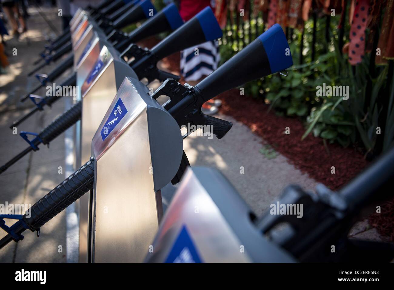 An art installation of mock AR-15 rifles, designed in a manner similar ...