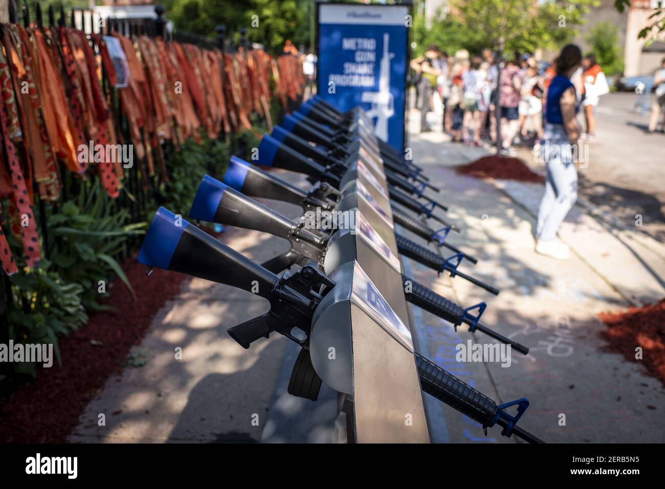 An art installation of mock AR-15 rifles, designed in a manner similar ...