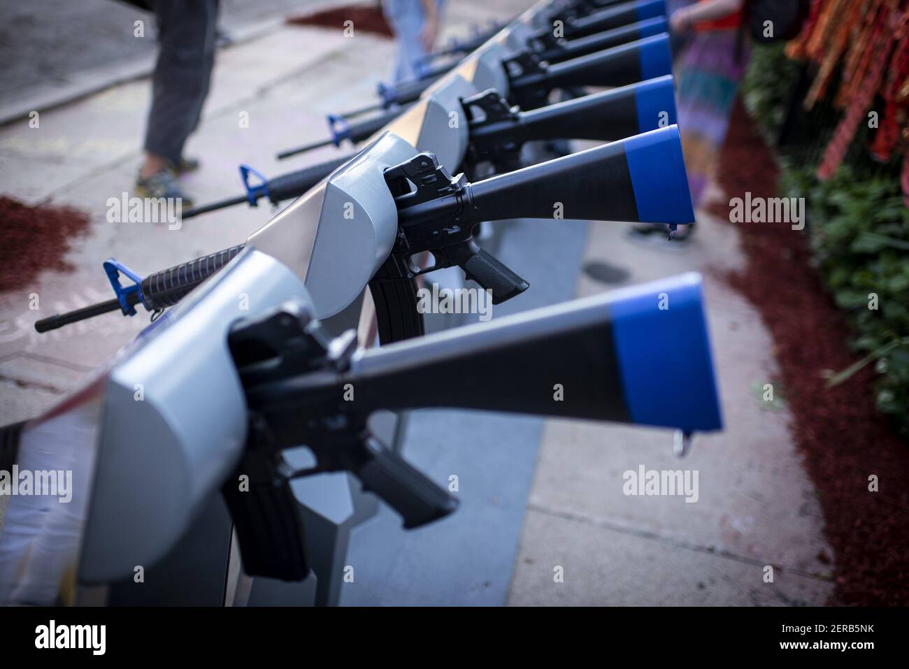 An art installation of mock AR-15 rifles, designed in a manner similar ...