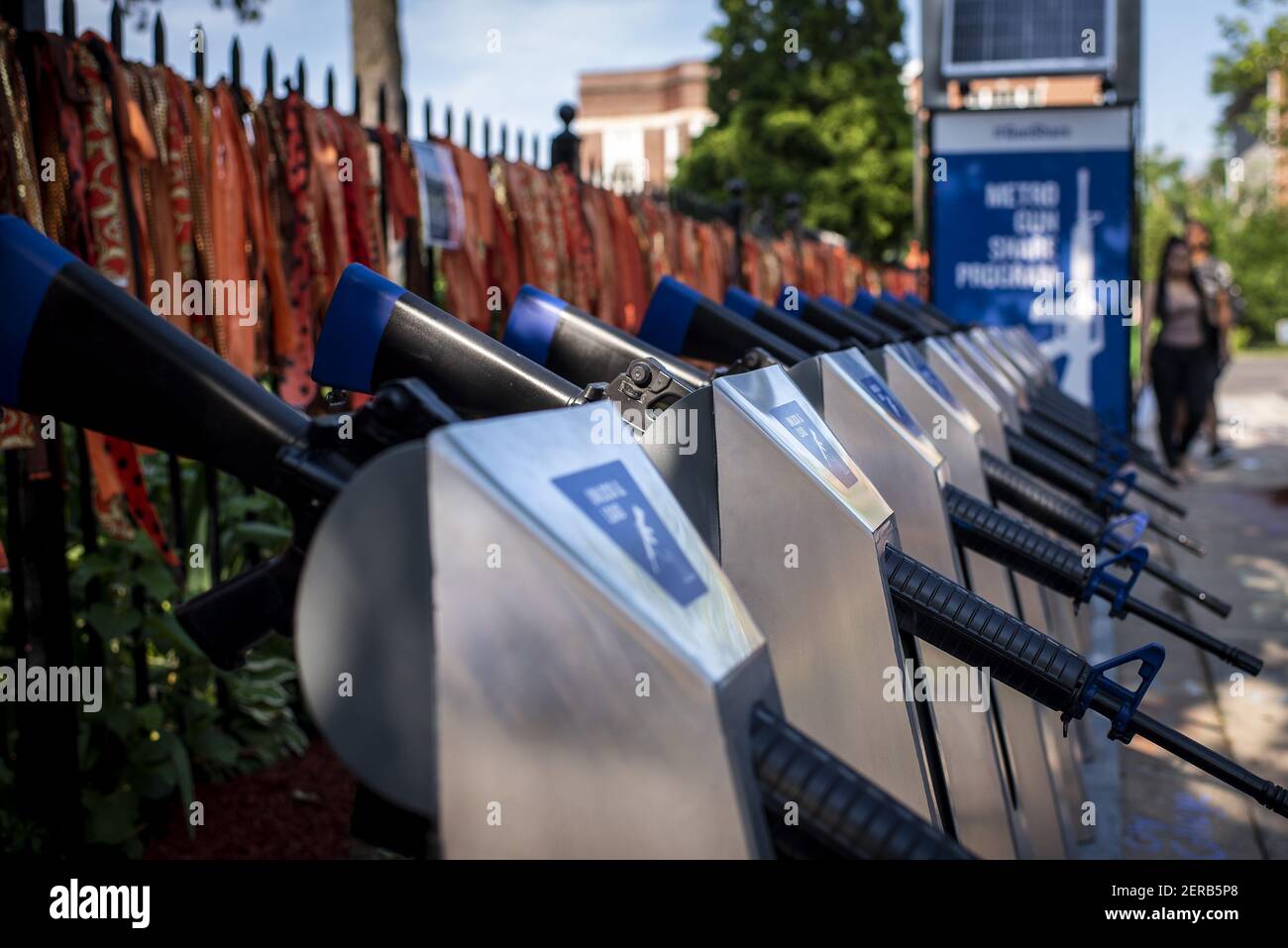 An art installation of mock AR-15 rifles, designed in a manner similar ...