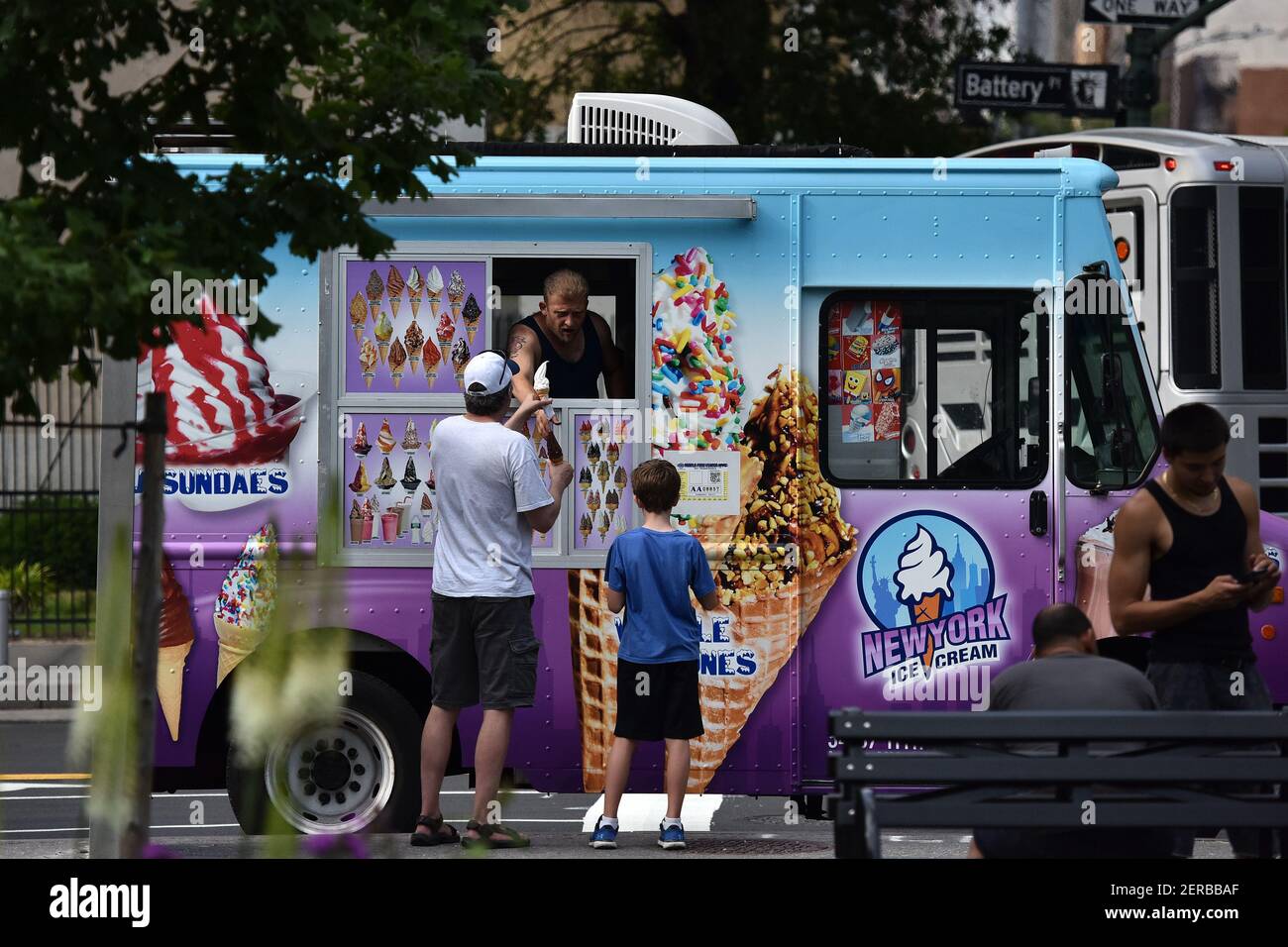 Pedestrians buy ice cream from an ice cream truck parked in Battery ...