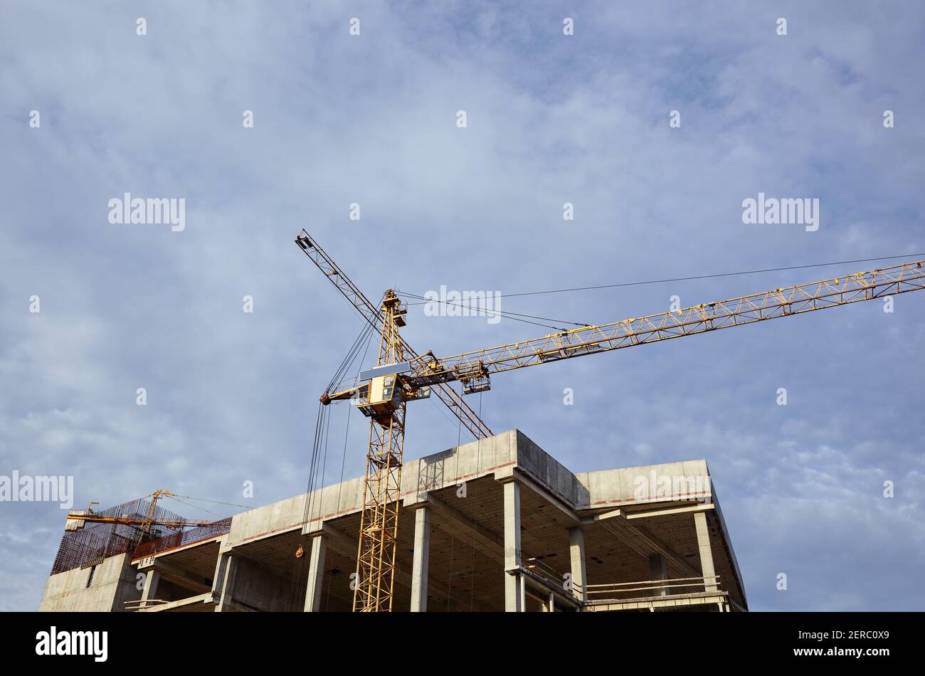 Tower crane building a house. Concrete building under construction ...
