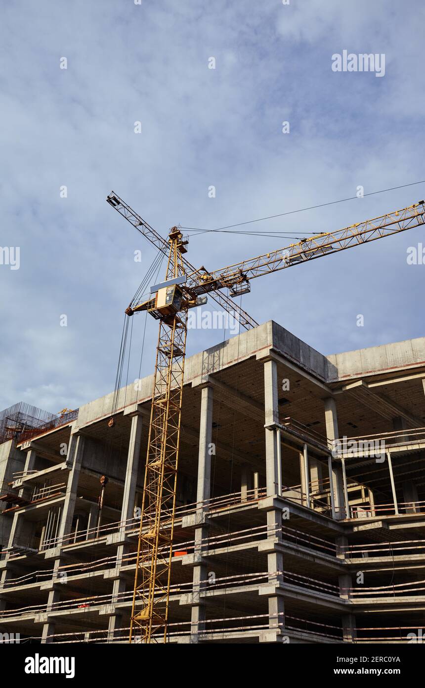 Tower crane building a house. Concrete building under construction ...