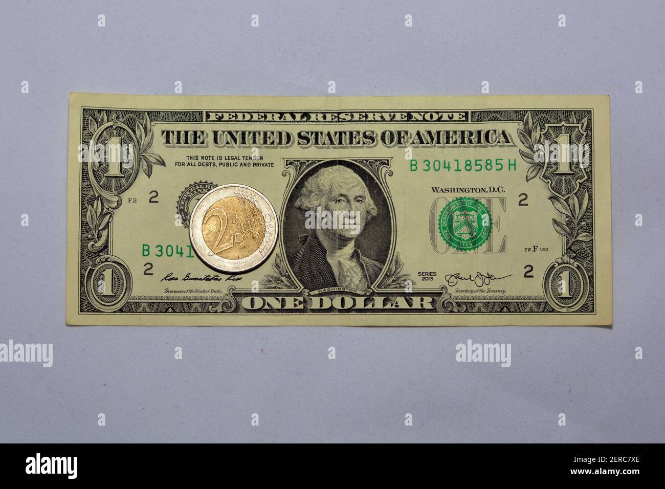 one American dollar banknote and 2 Euros coin, American money versus ...