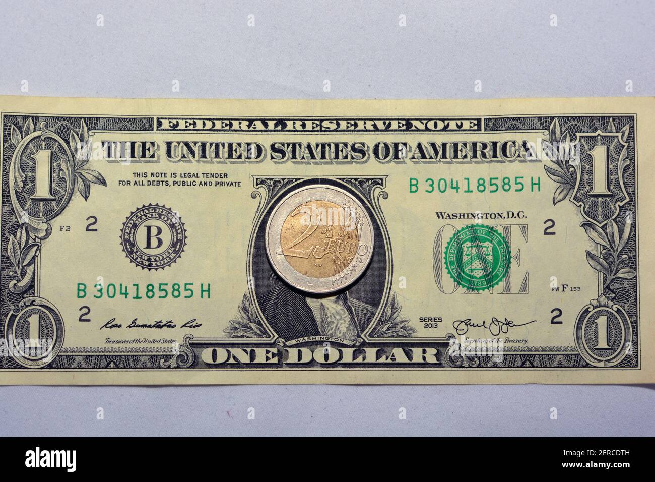 one American dollar banknote and 2 Euros coin, American money versus ...