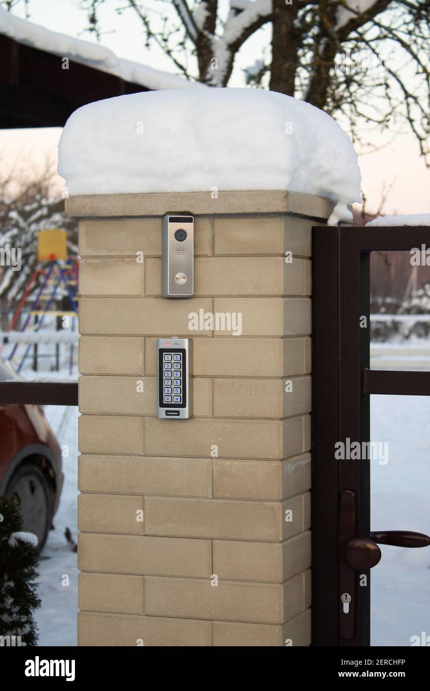 Silver intercom call panel with blue number buttons and a video camera ...