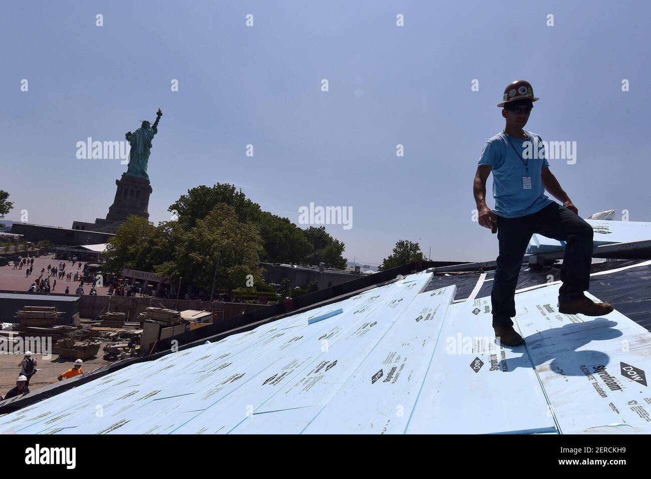 Roof foreman Robert Parsons is seen placing insulation on the still ...
