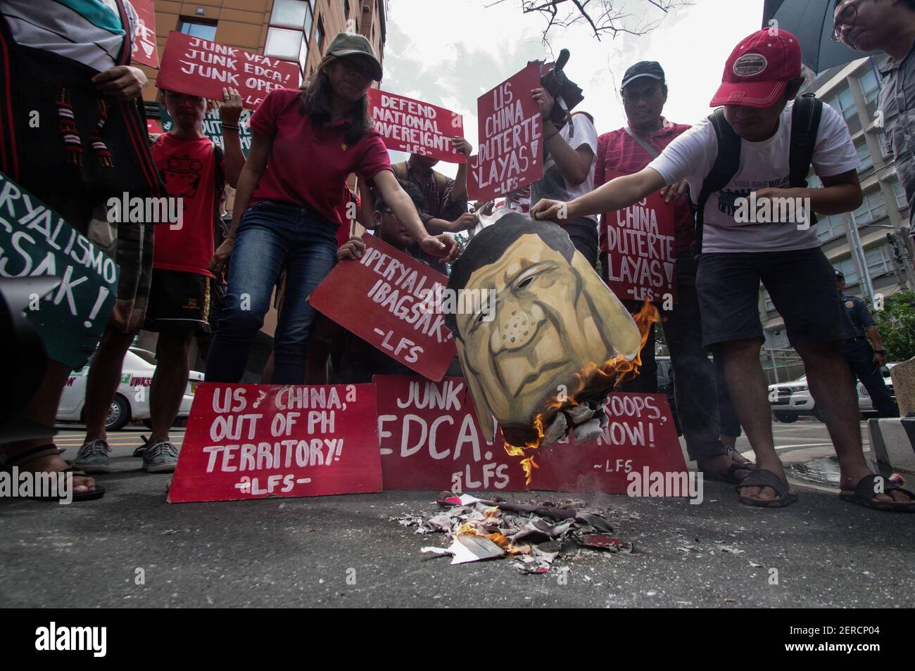 Youth group League of Filipino Students burn a cardboard mask of ...