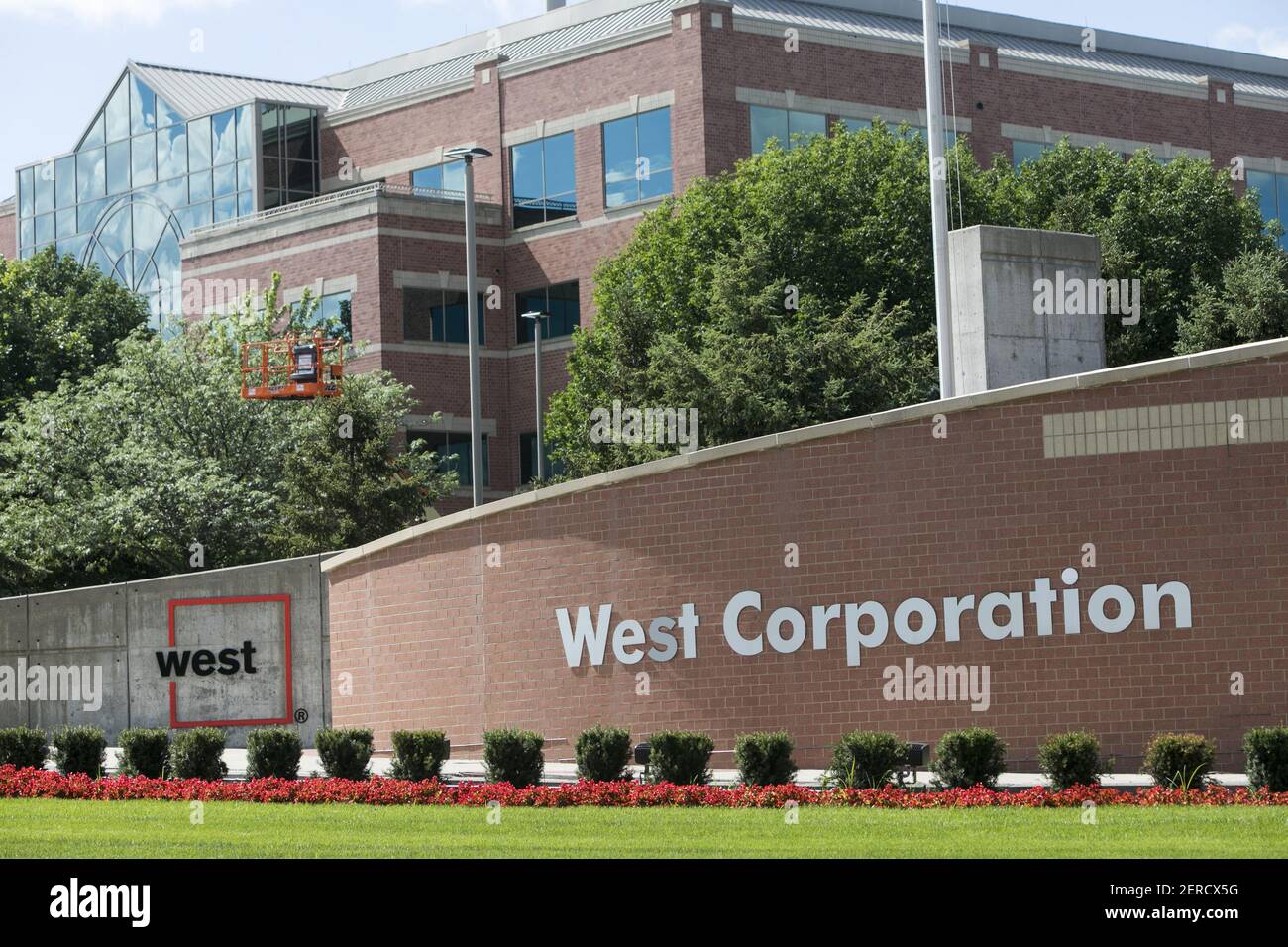 A logo sign outside of the headquarters of the West Corporation in ...