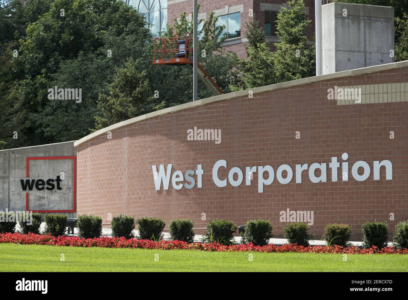 A logo sign outside of the headquarters of the West Corporation in ...