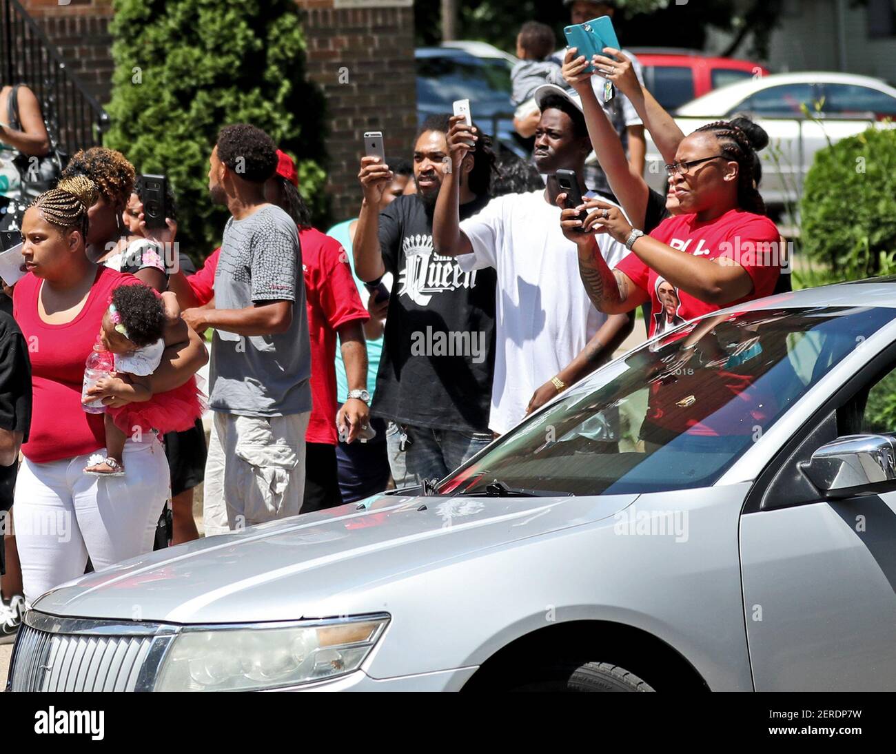 Friends and family take pictures and video as the casket of Thurman ...