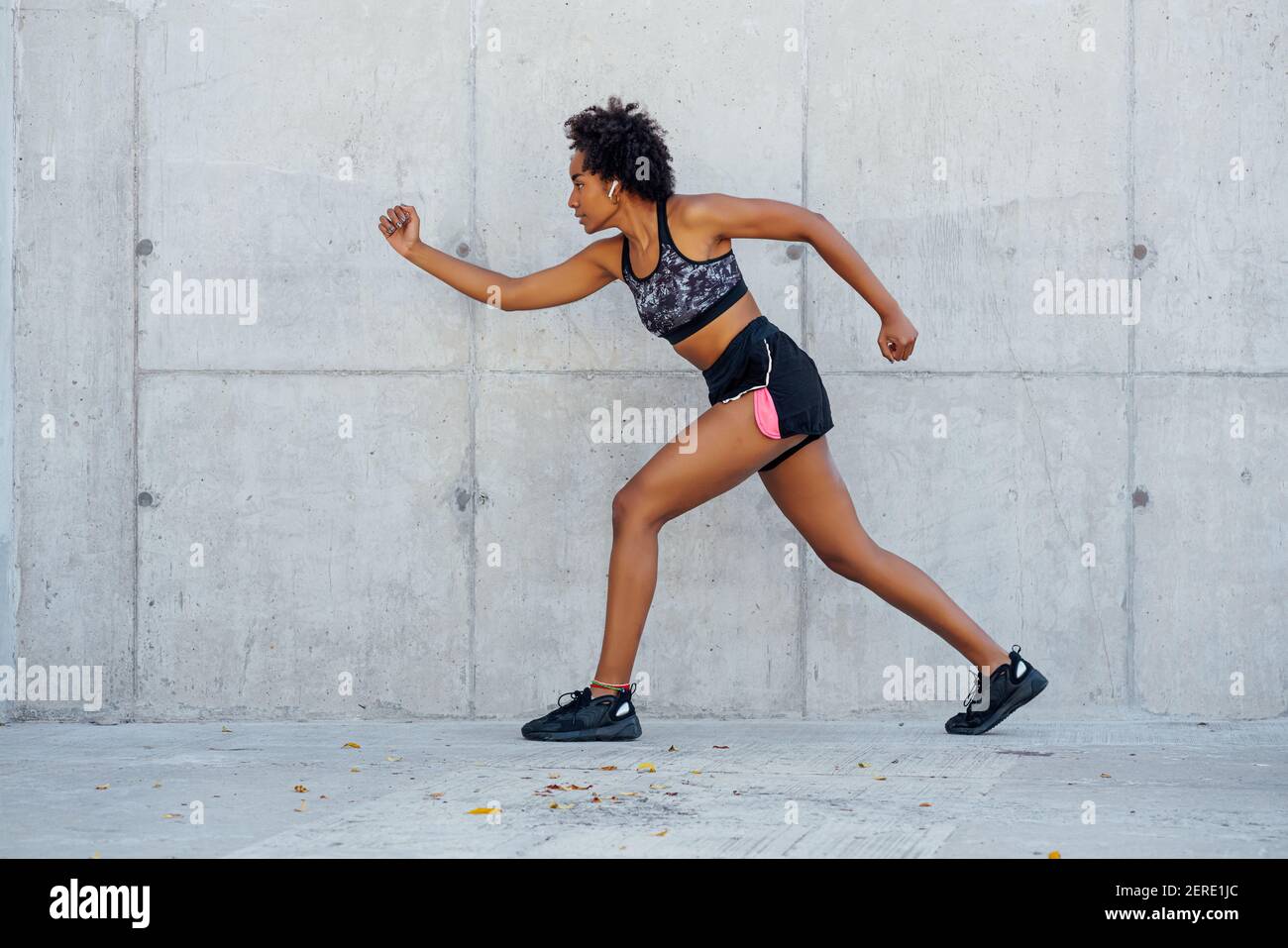 Afro athletic woman running outdoors Stock Photo - Alamy