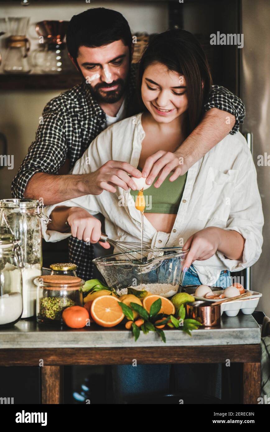 Young happy couple cooking together in kitchen. Caucasian man face in ...