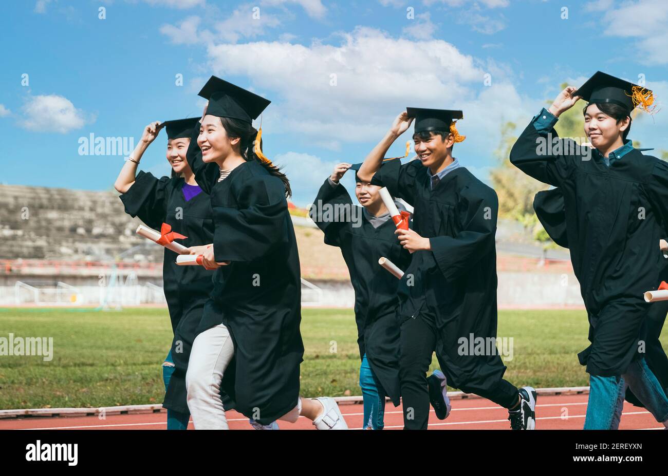 Group of Students Celebrating Graduation and running on the track Stock ...