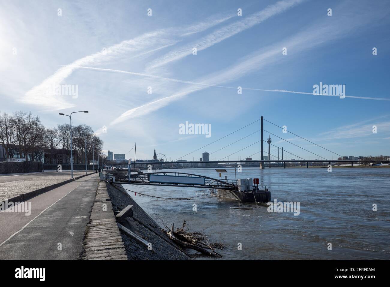 Sunny view promenade riverside and bridge toward pier, pontoon or buoy ...