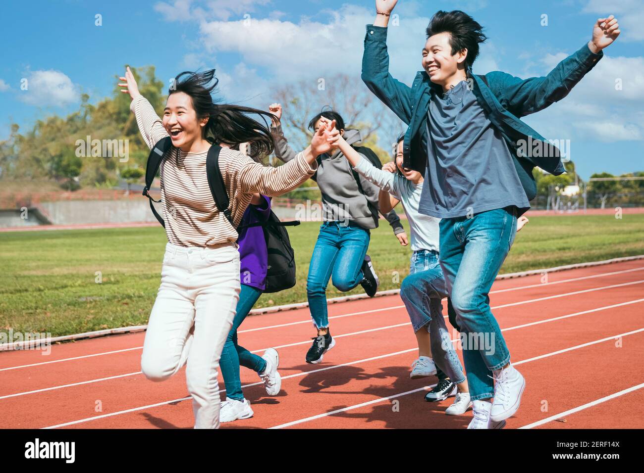 Happy young group students running Across Field Stock Photo - Alamy