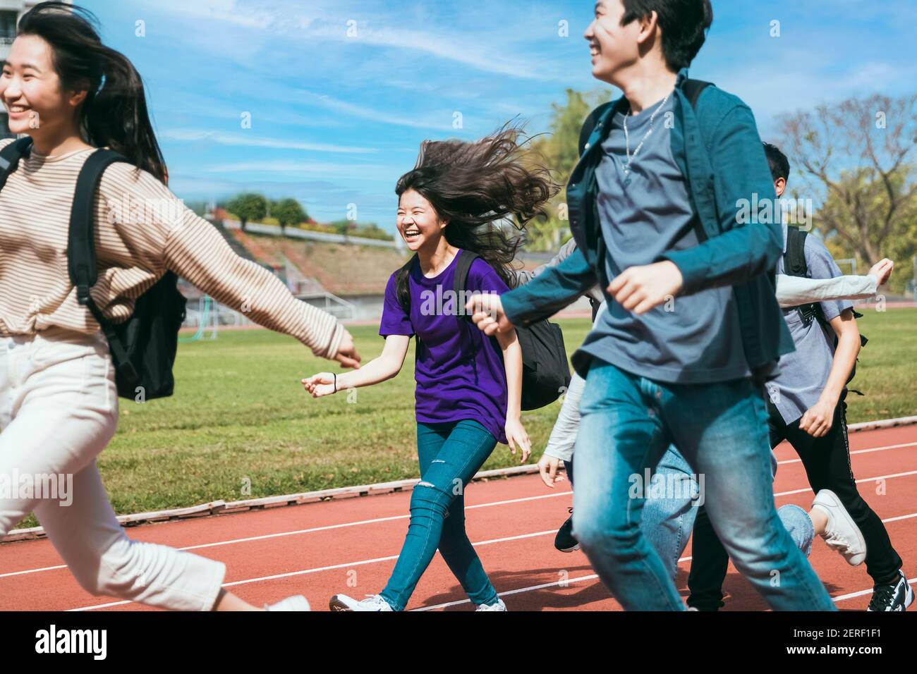 Happy young group students running Across Field Stock Photo - Alamy