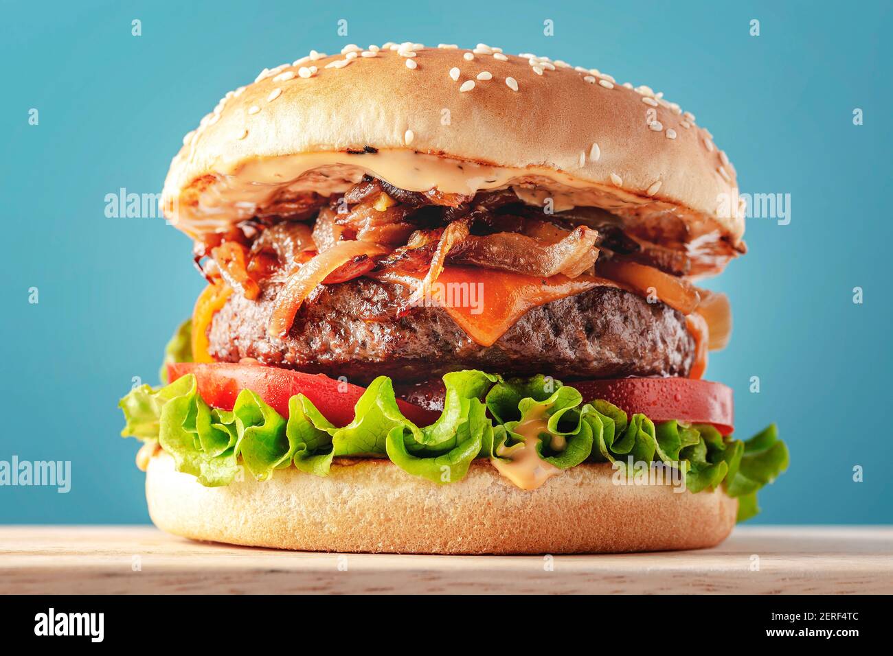 Classic layered hamburger with lettuce, tomatoes, cheddar cheese and ...