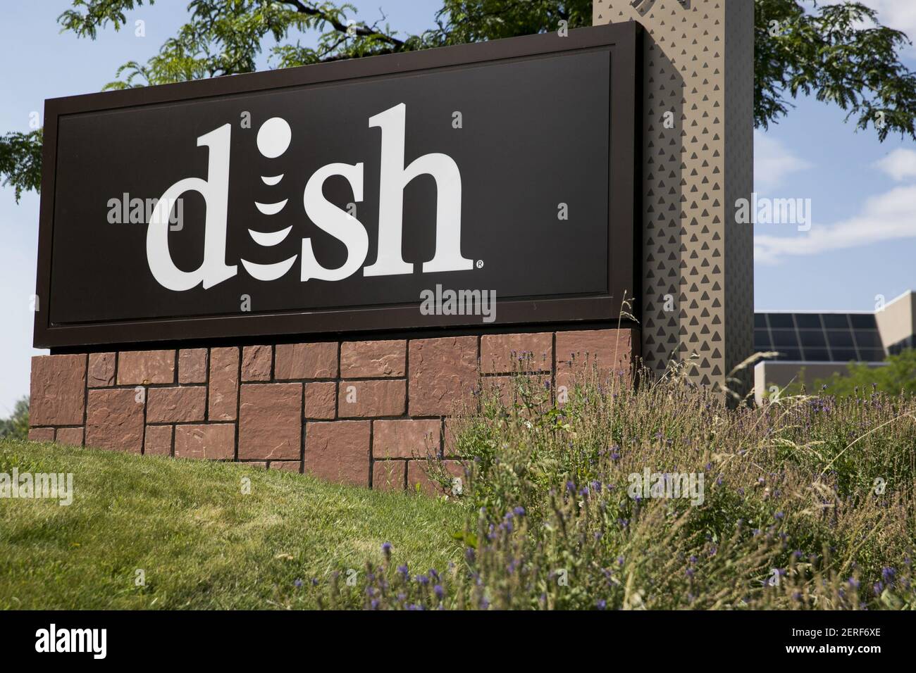 A logo sign outside of a facility occupied by the Dish Network ...