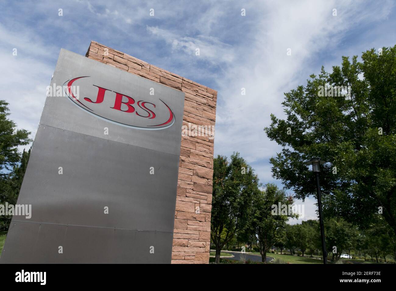 A logo sign outside of the headquarters of JBS USA Holdings, Inc., in ...