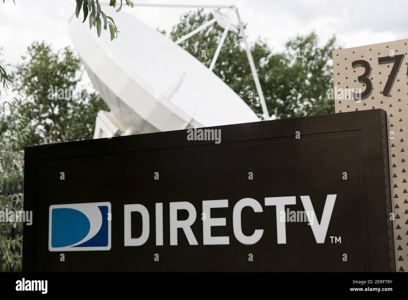 A logo sign outside of a facility occupied by DirecTV in Englewood ...