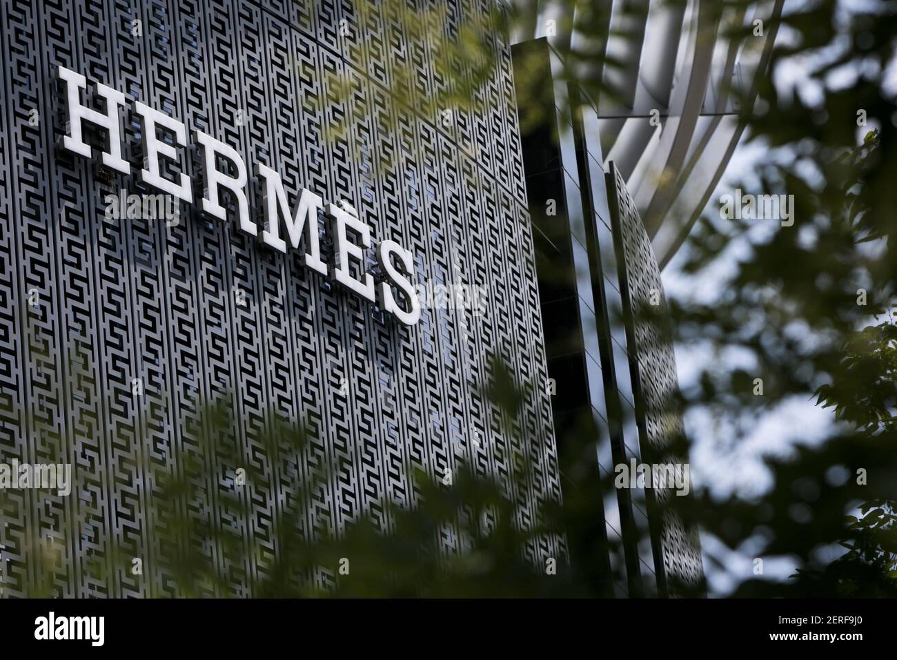 A logo sign outside of a Hermes retail store location in Denver ...