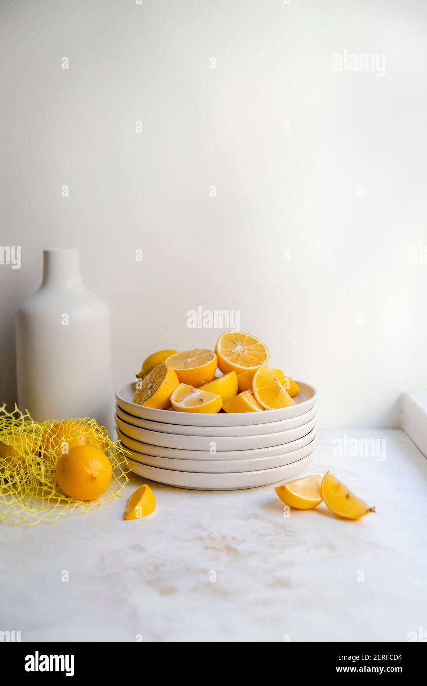 Stack of plates with sliced lemons Stock Photo - Alamy