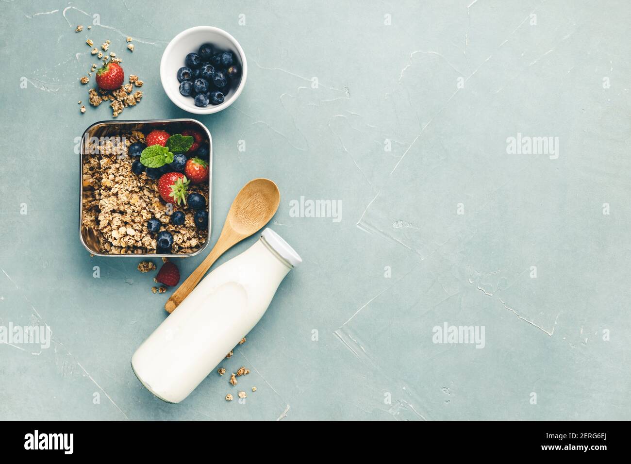 Metal container with ingredients for healthy breakfastt: granola, milk ...