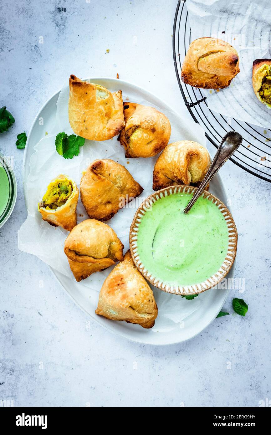 Flat lay image of a samosa platter with restaurant style yogurt mint ...