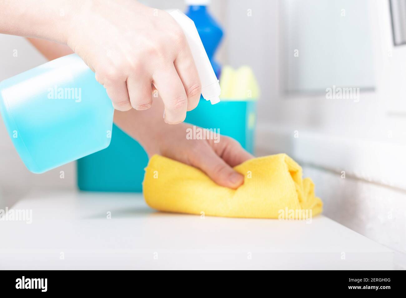 Blue chlorine bottle spray. Woman using detergent and wipe. Cleaning ...