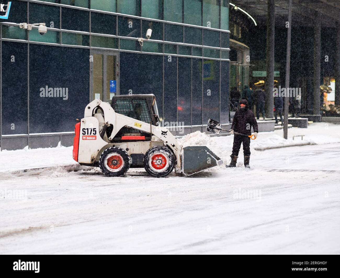 Moscow. Russia. February 12, 2021. A utility worker with a shovel and a ...