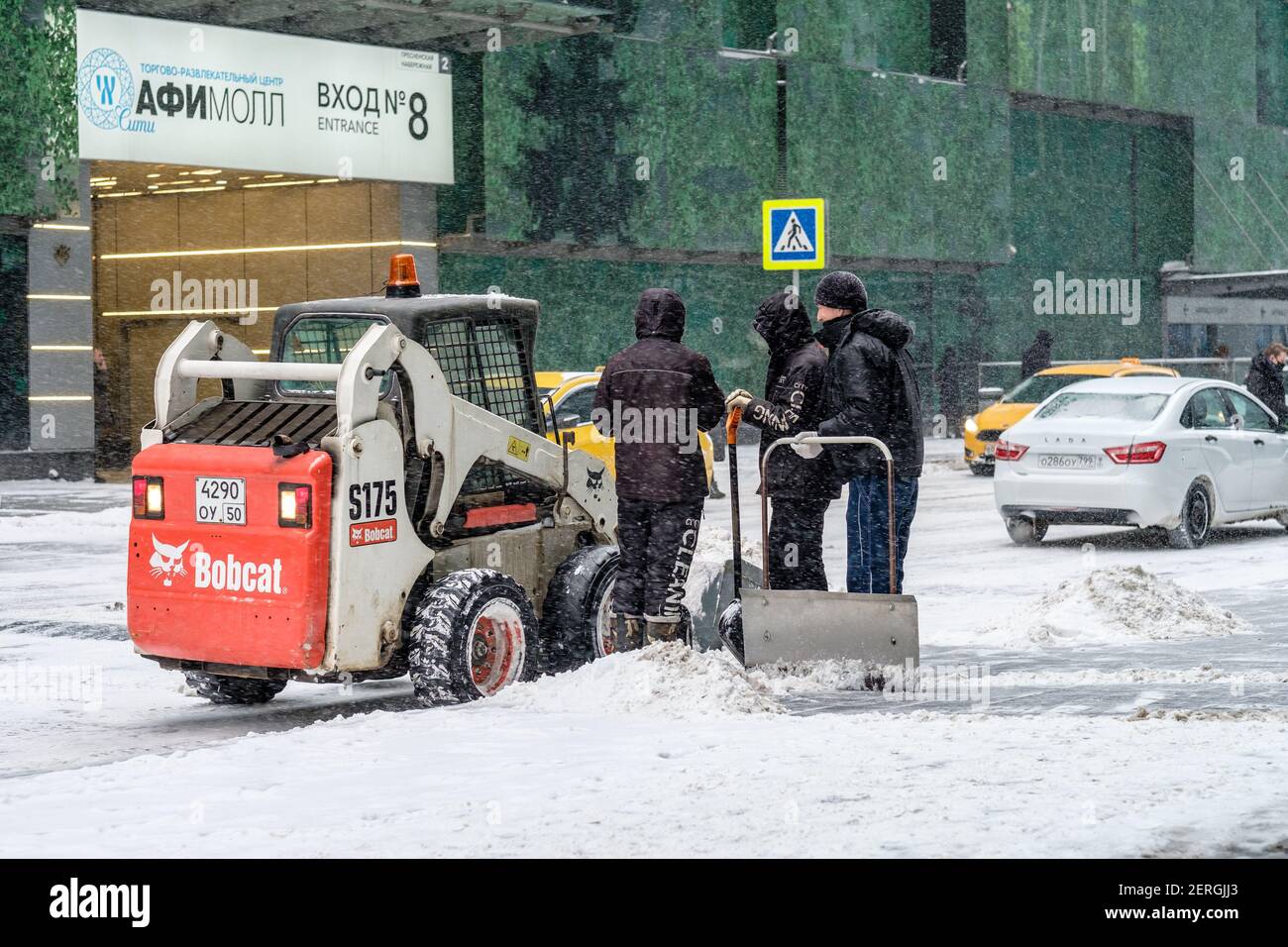 Moscow. Russia. February 12, 2021. Several utility workers with shovels ...