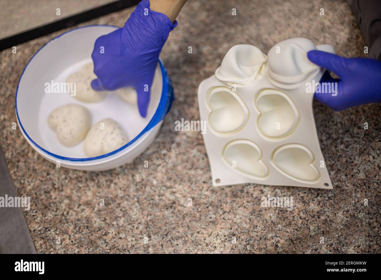 Closeup female confectioner hands white chocolate caramel shape hearts ...