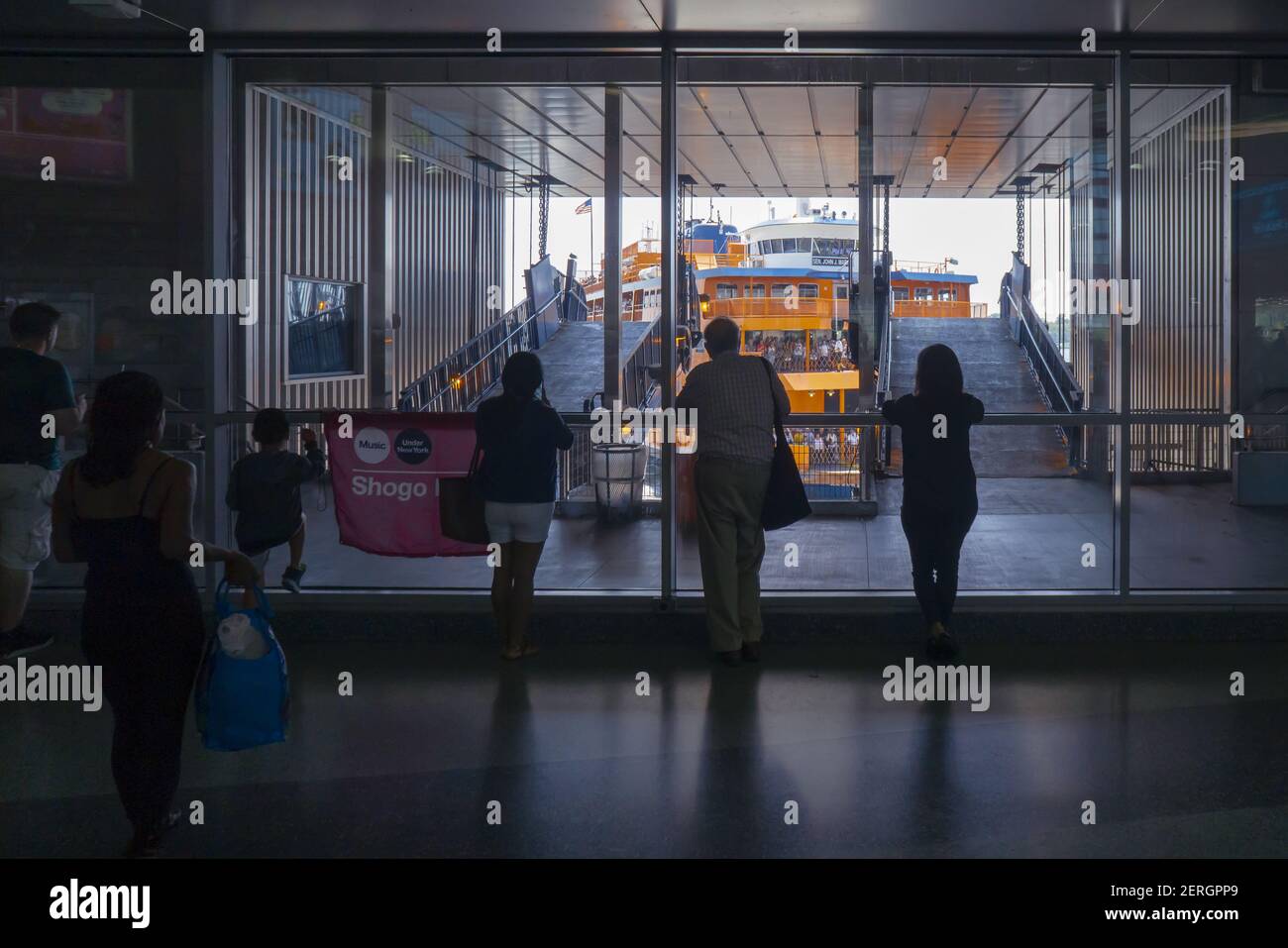 Commuters watch the Sen. John J. Marchi Staten Island Ferry dock at the ...