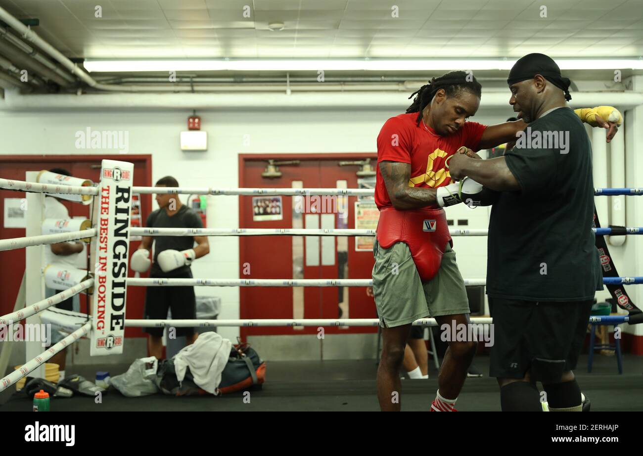 Chris Ousley gets assistance taking off his gloves after a workout with ...