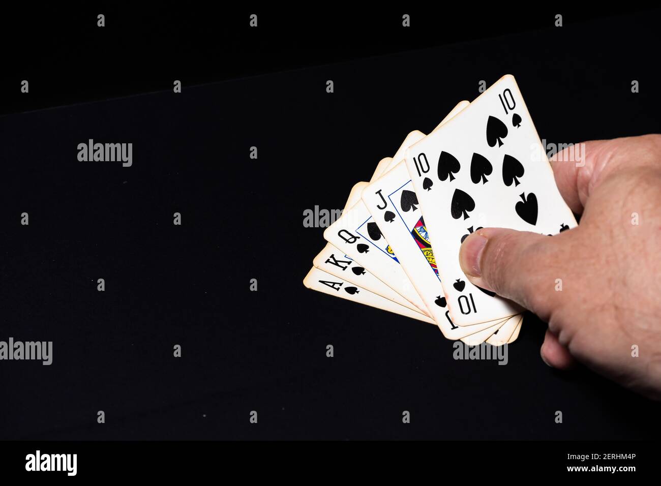 Pique royal flush in a poker game. Black background Stock Photo - Alamy