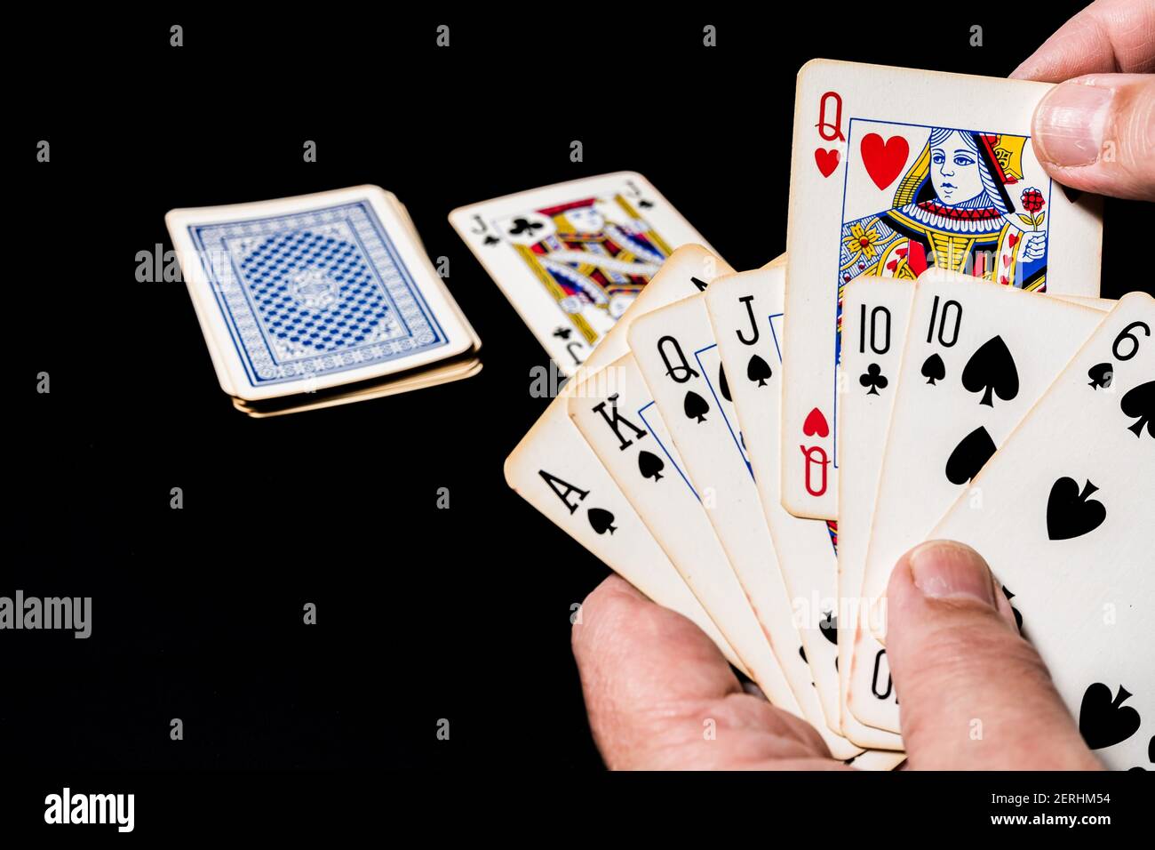 Poker card game on a table. Hand holding some cards showing his game ...